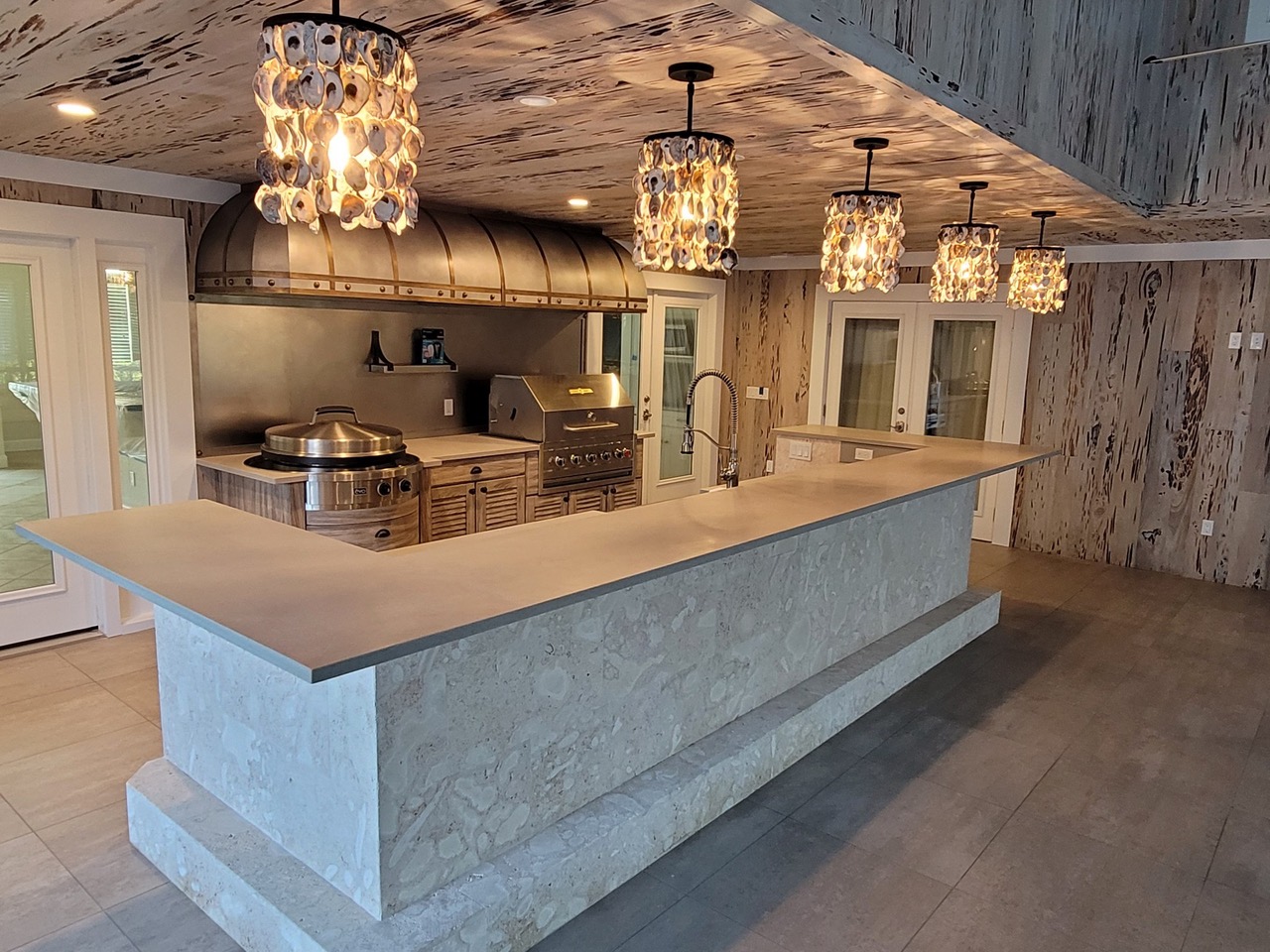 The custom metal range hood pictured above serves as the focal point of ...